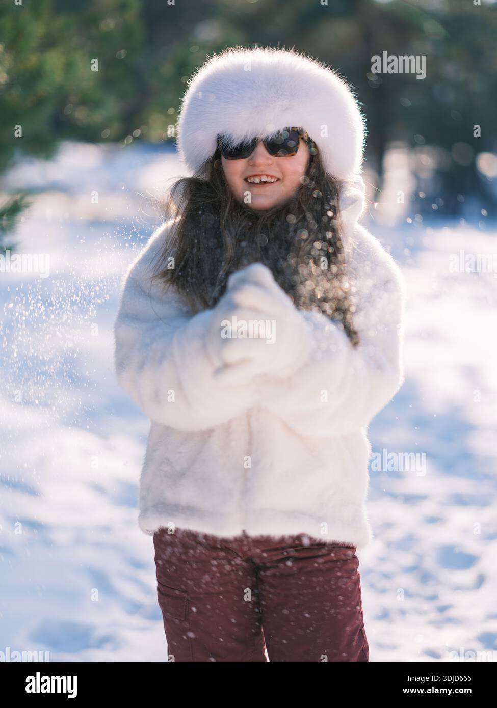 Happy girl smiling in white fur hat and sunglasses posing in sunny ...