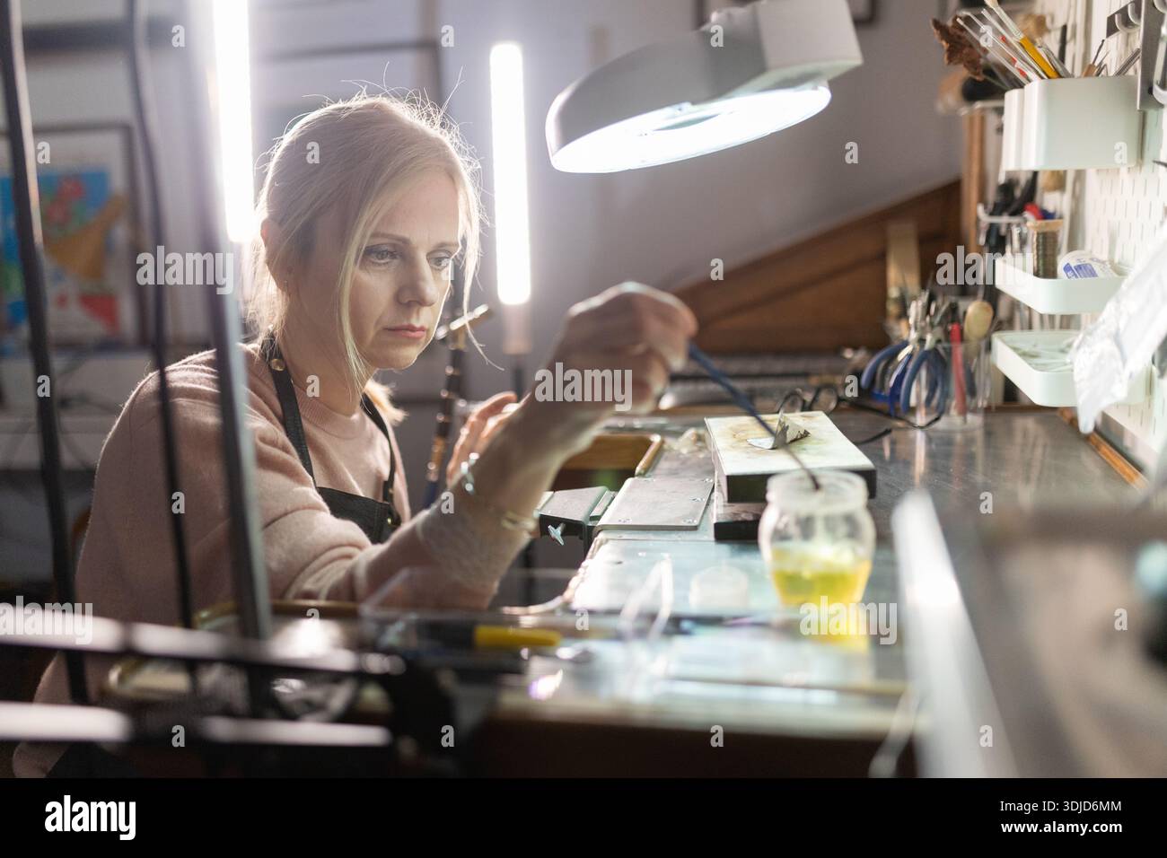 Focused goldsmith woman working on hi-res stock photography and images ...