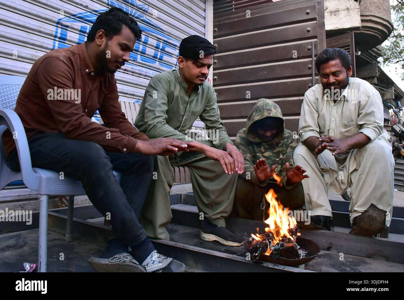 HYDERABAD, PAKISTAN, JAN 26: People warm their hands on bone-fire to ...