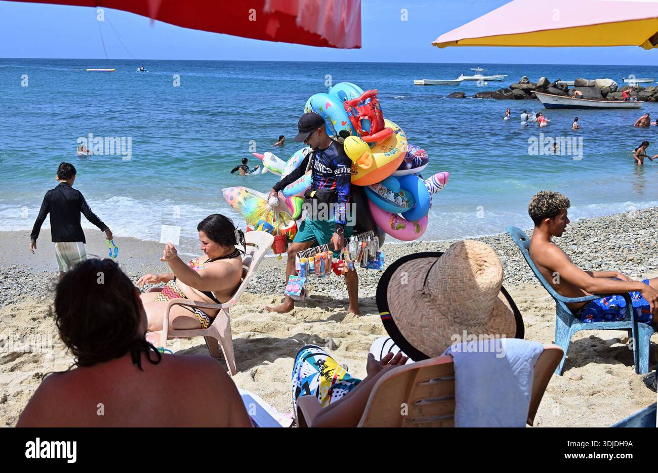 Genre photography. La Guaira Beach. A street vendor sells inflatable ...