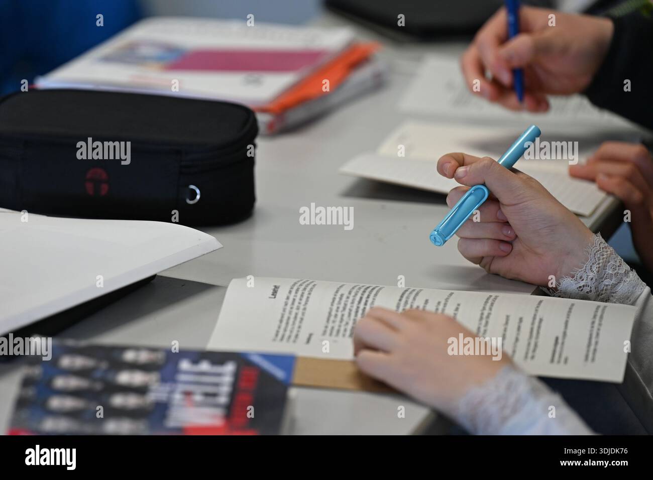 15 January 2026, Rhineland-Palatinate, Mainz: A pupil holds a pen and ...