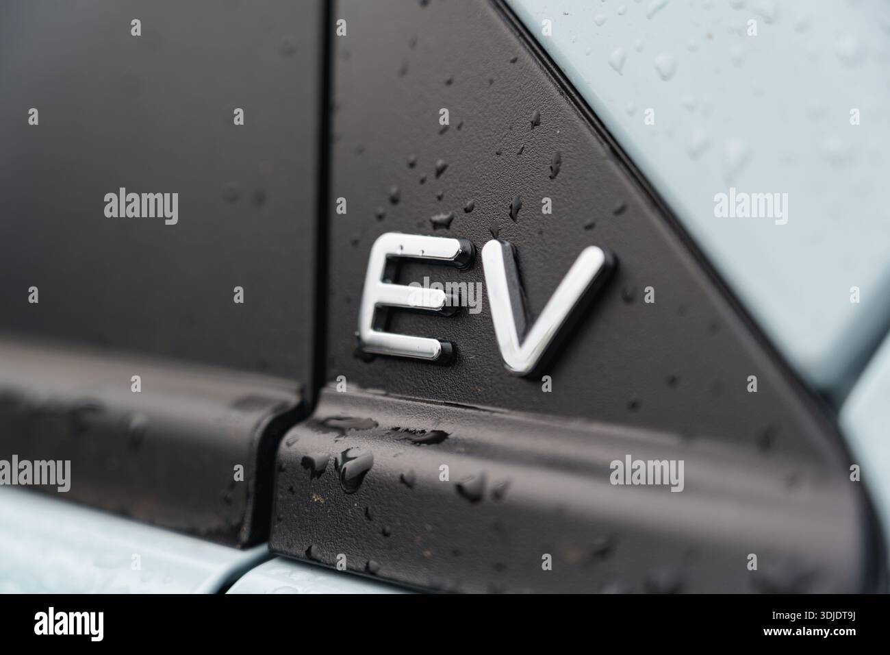 EV badge detail on electric vehicle body panel, indicating a car ...