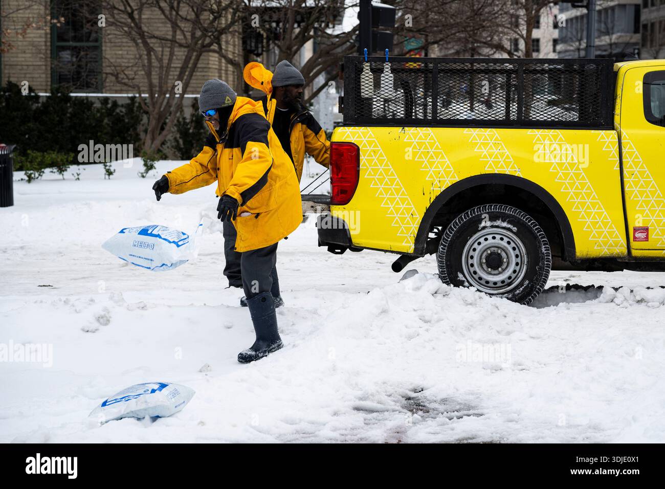 Workers unload ice melt after a major winter storm, in downtown ...
