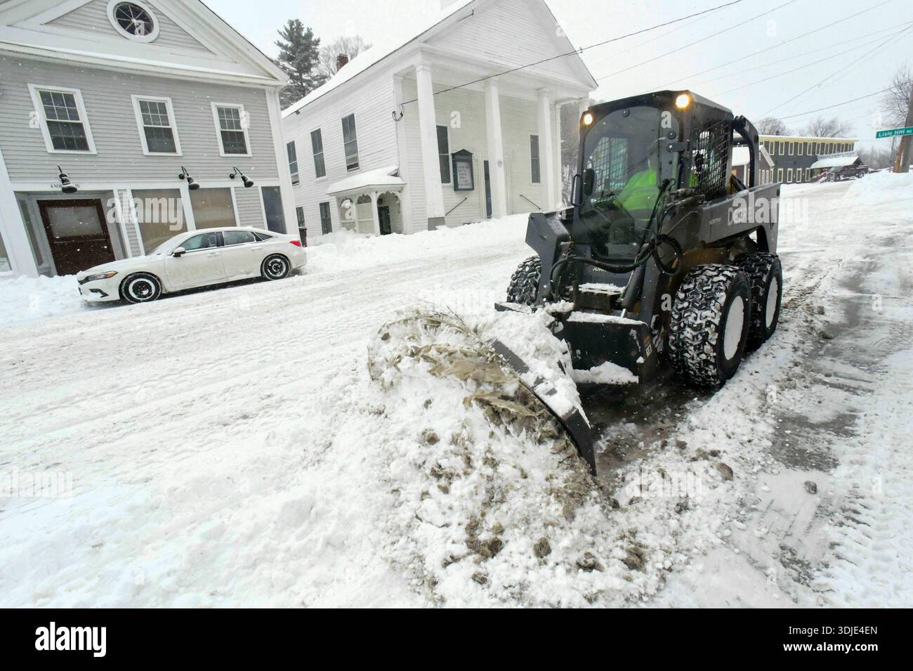 Public works employees clear off the snow from the side of Route 100 on ...