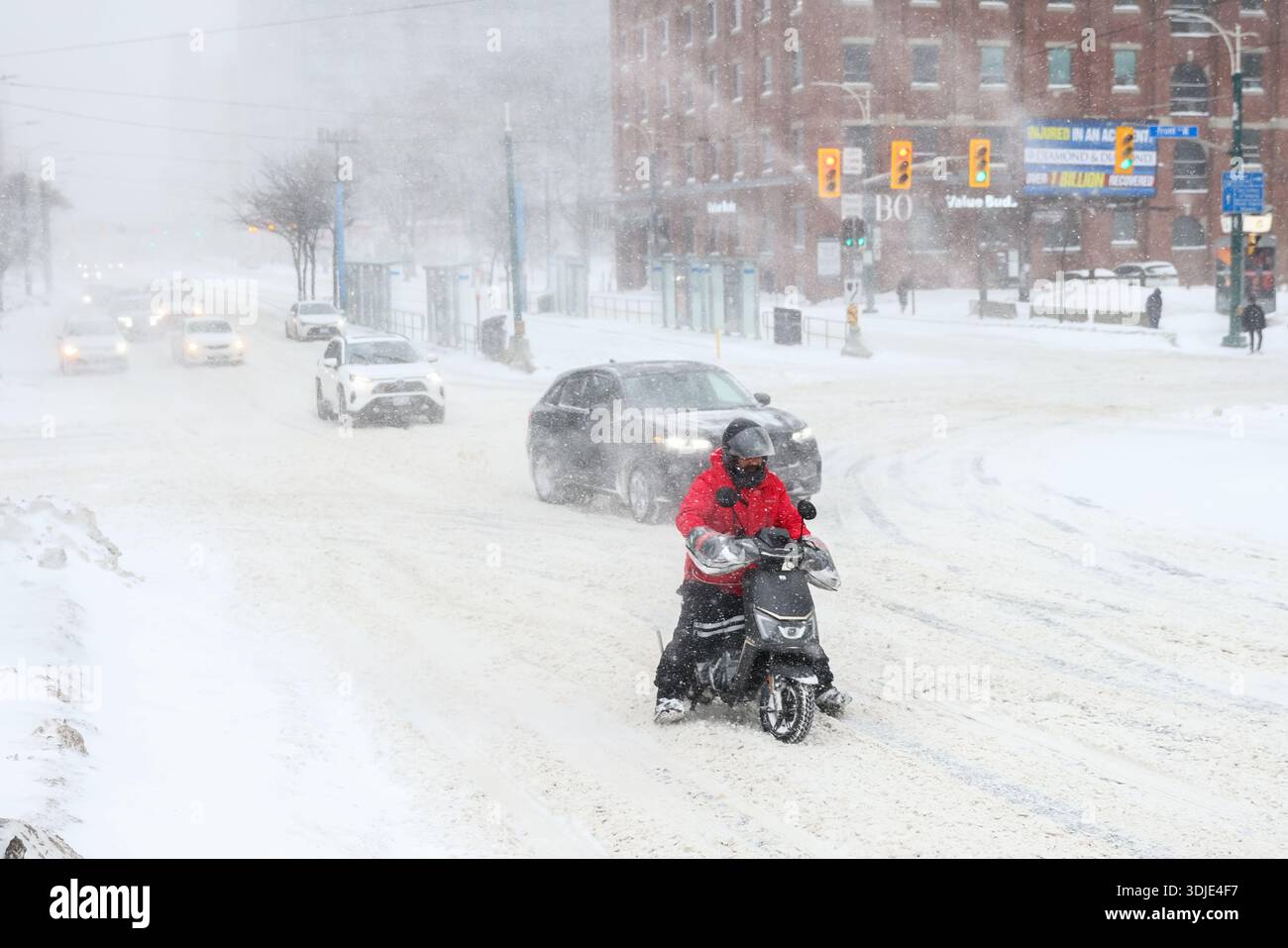 A person rides an electric scooter though downtown Toronto as a winter ...