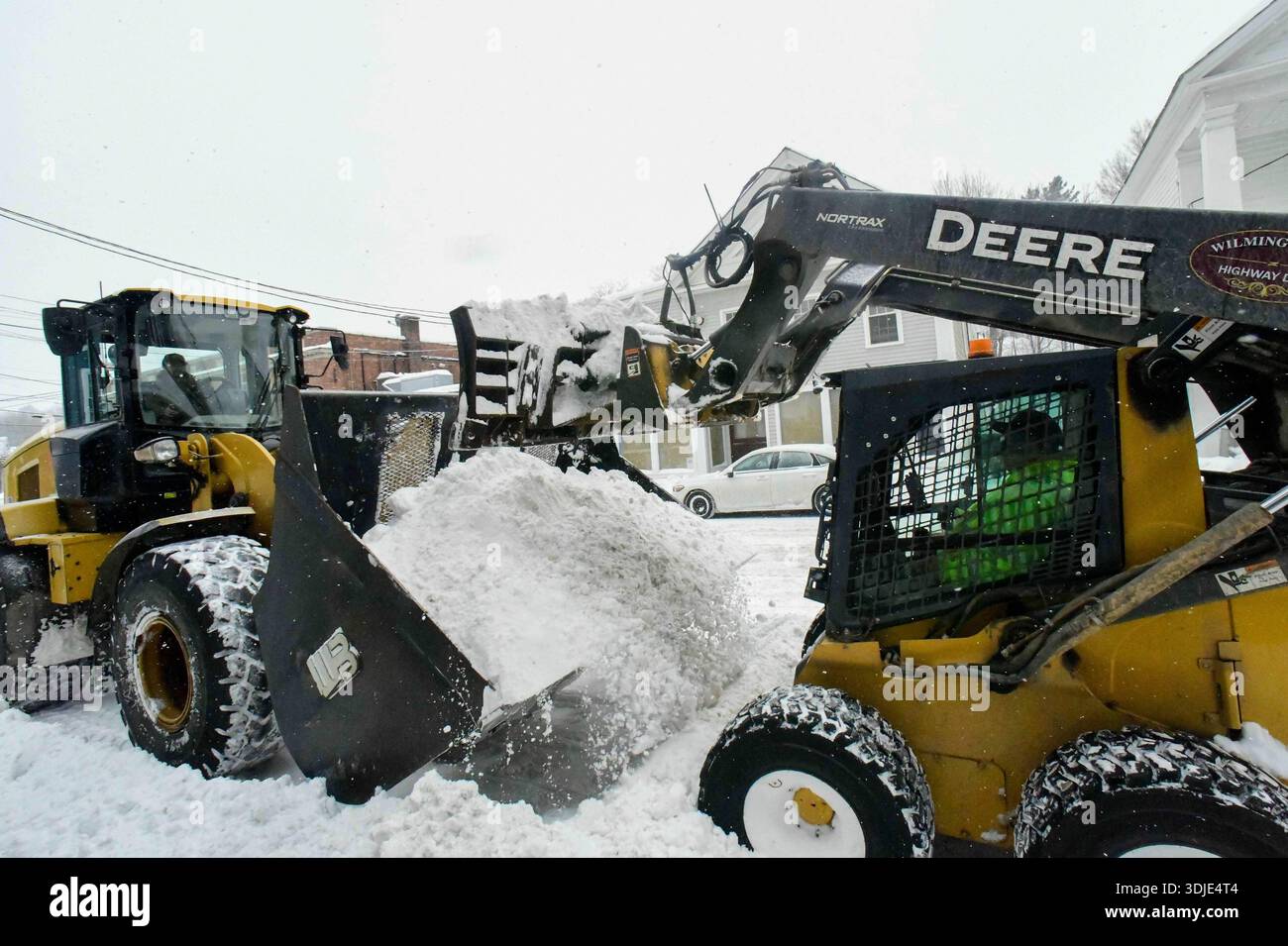 Public works employees from Wilmington, Vt., clear off the snow from ...
