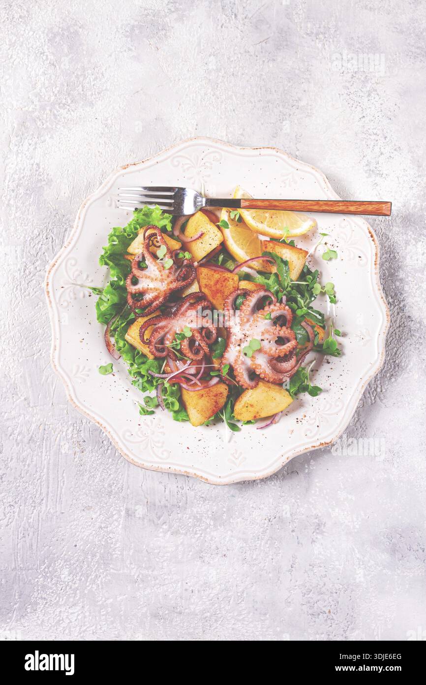 Grilled octopus with baked potatoes and fresh herbs, on a decorative ...