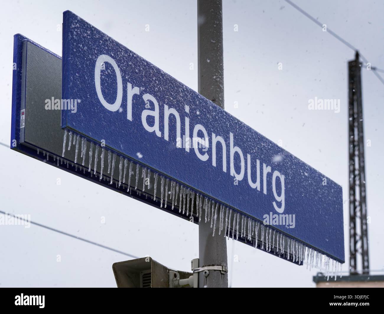 26 January 2026, Brandenburg, Oranienburg: Icicles hang from a sign at ...