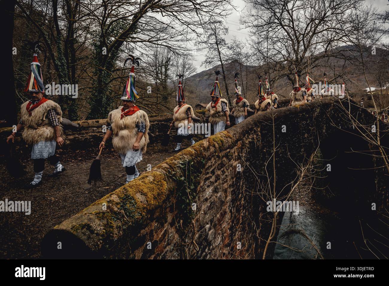 Ituren, Spain. 26 January, 2026: 'Joaldunak' cross a stone bridge ...