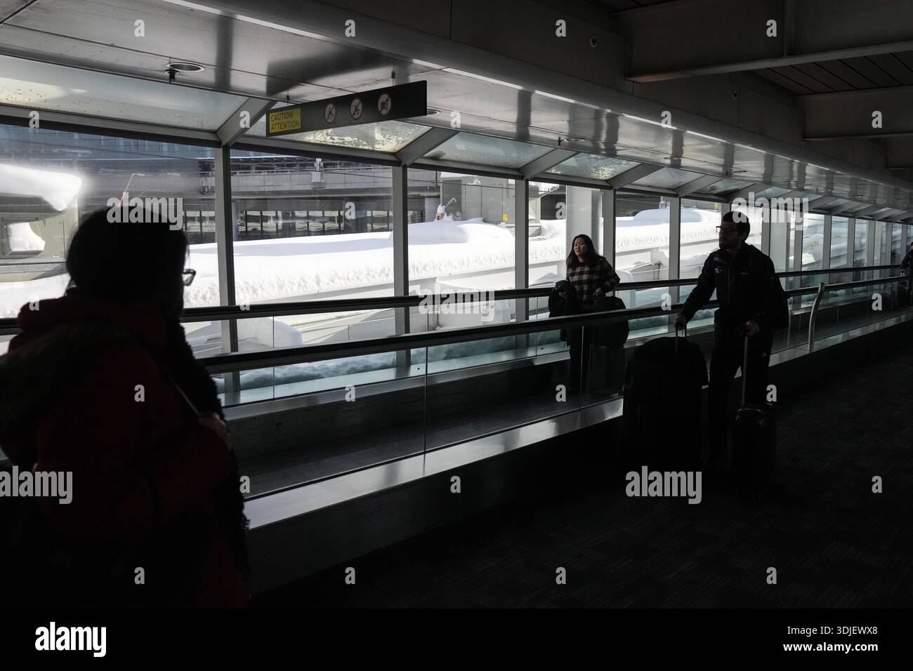 Passengers pass through Toronto's Pearson Airport as snow piles up ...