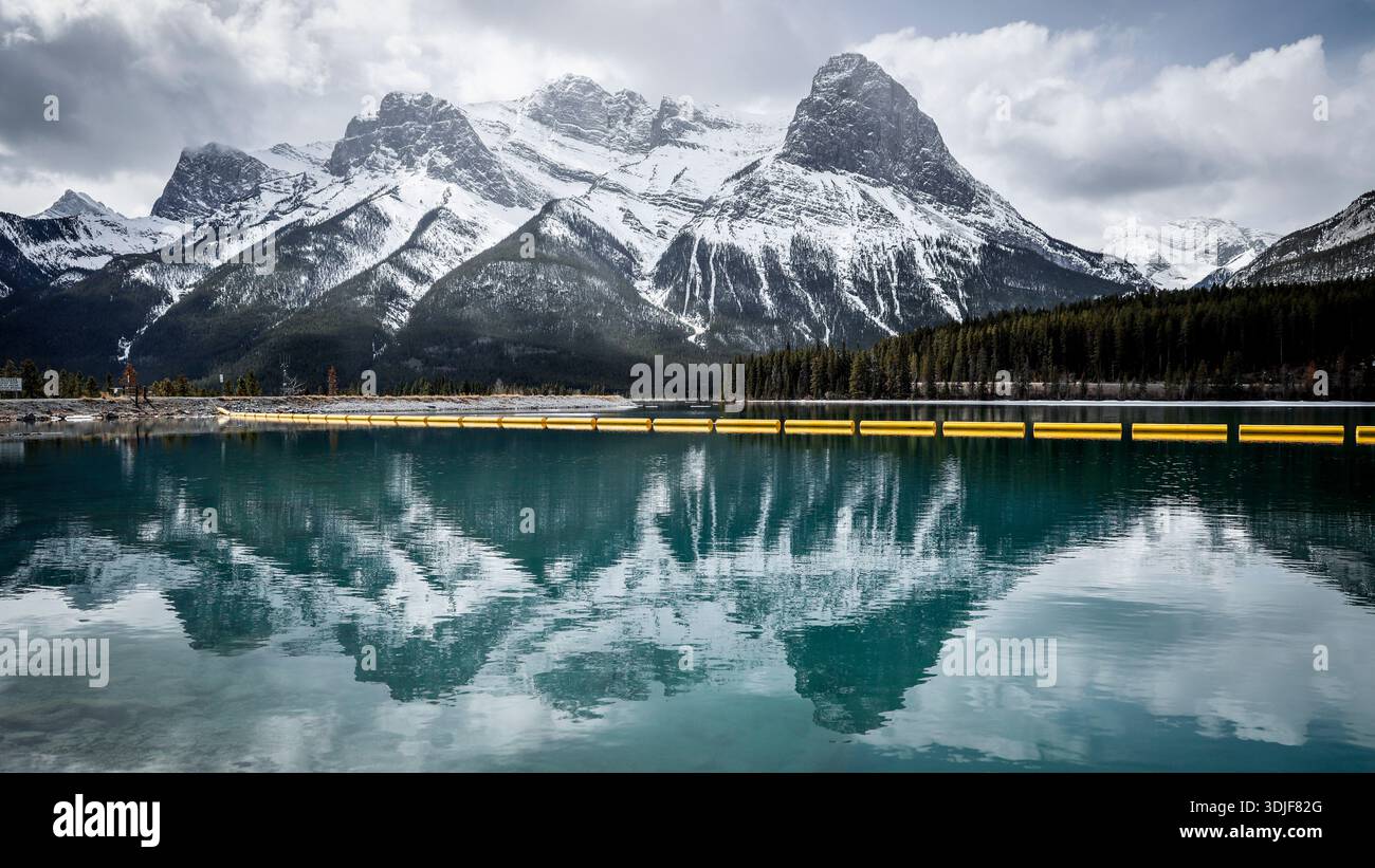 Mountains are reflected in a reservoir in Canmore, Alta., Monday, April ...