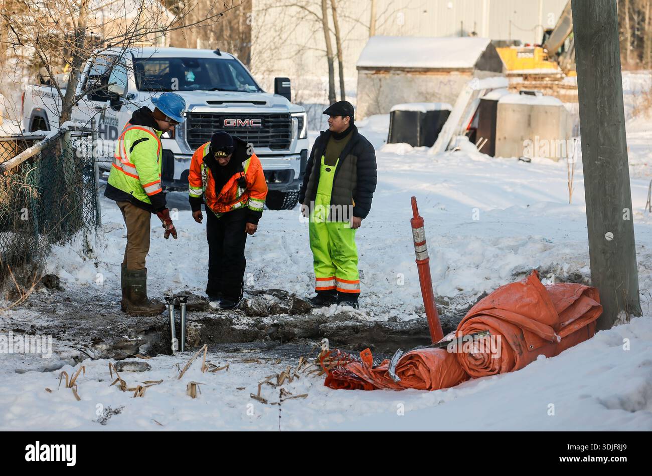 Crews work to fix a water main break in front of a home on the ...