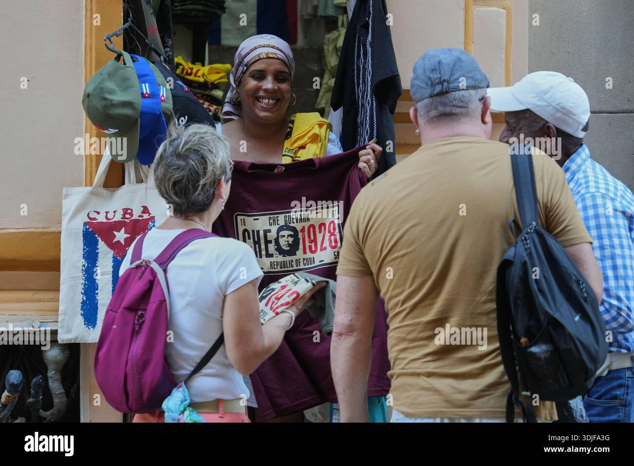 A vendor shows tourists a Che Guevara shirt in Havana, Monday, Jan. 26 ...