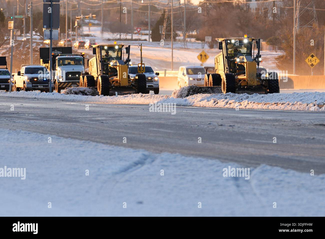 Work crews use plows to push snow and ice off the road on President ...