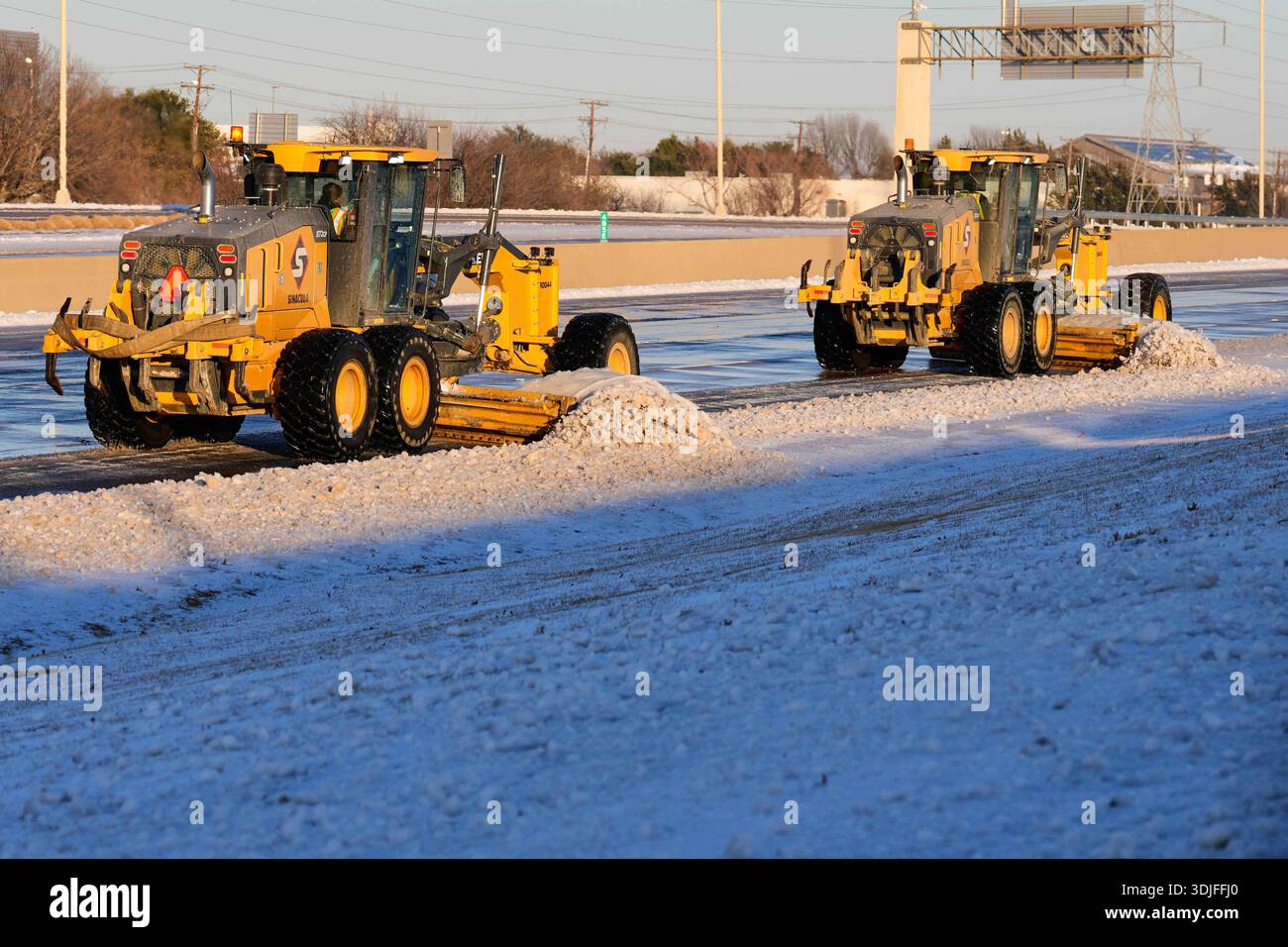 Work crews use plows to push snow and ice off the road on President ...