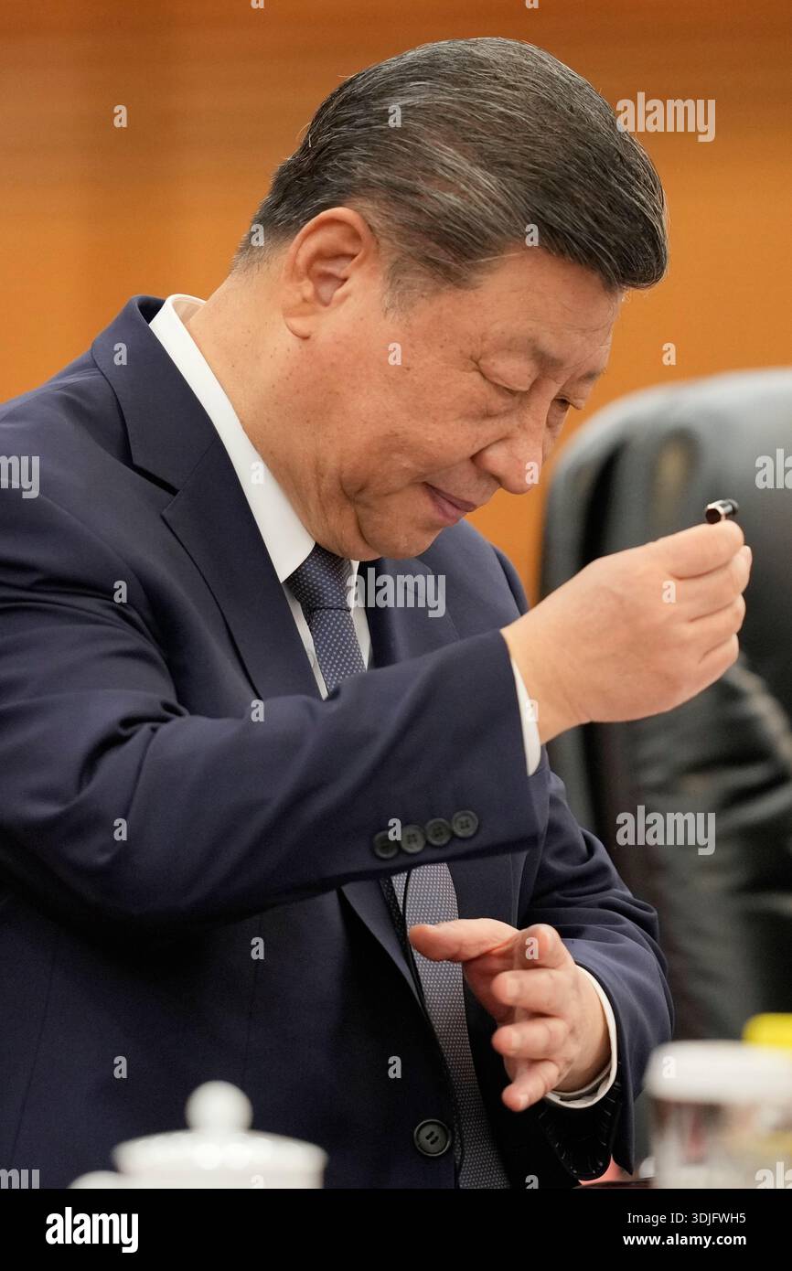 Chinese President Xi Jinping removes earphone after listening to ...