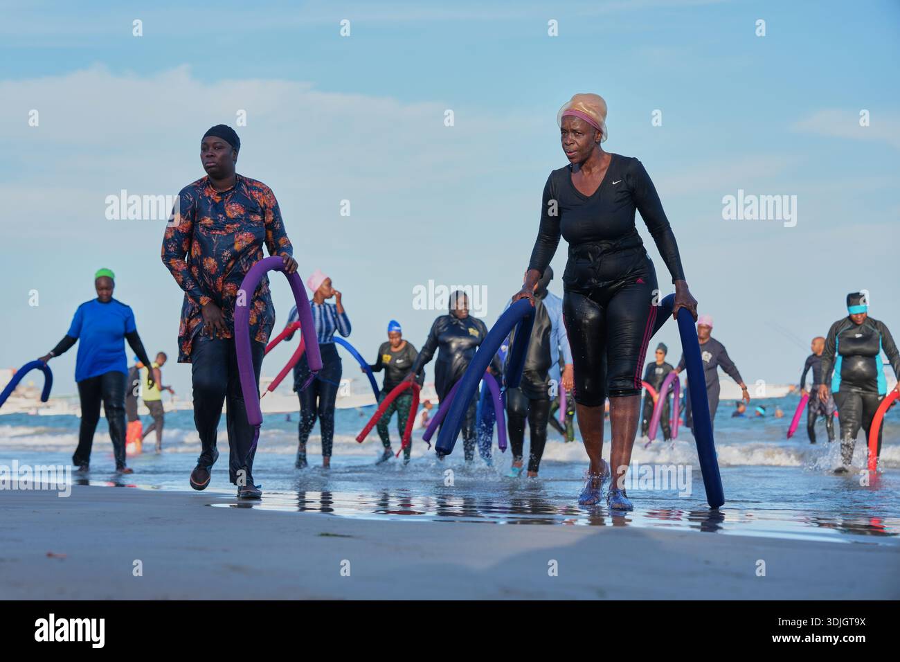 FILE - Participants walk out of the ocean after a group aquatic therapy ...