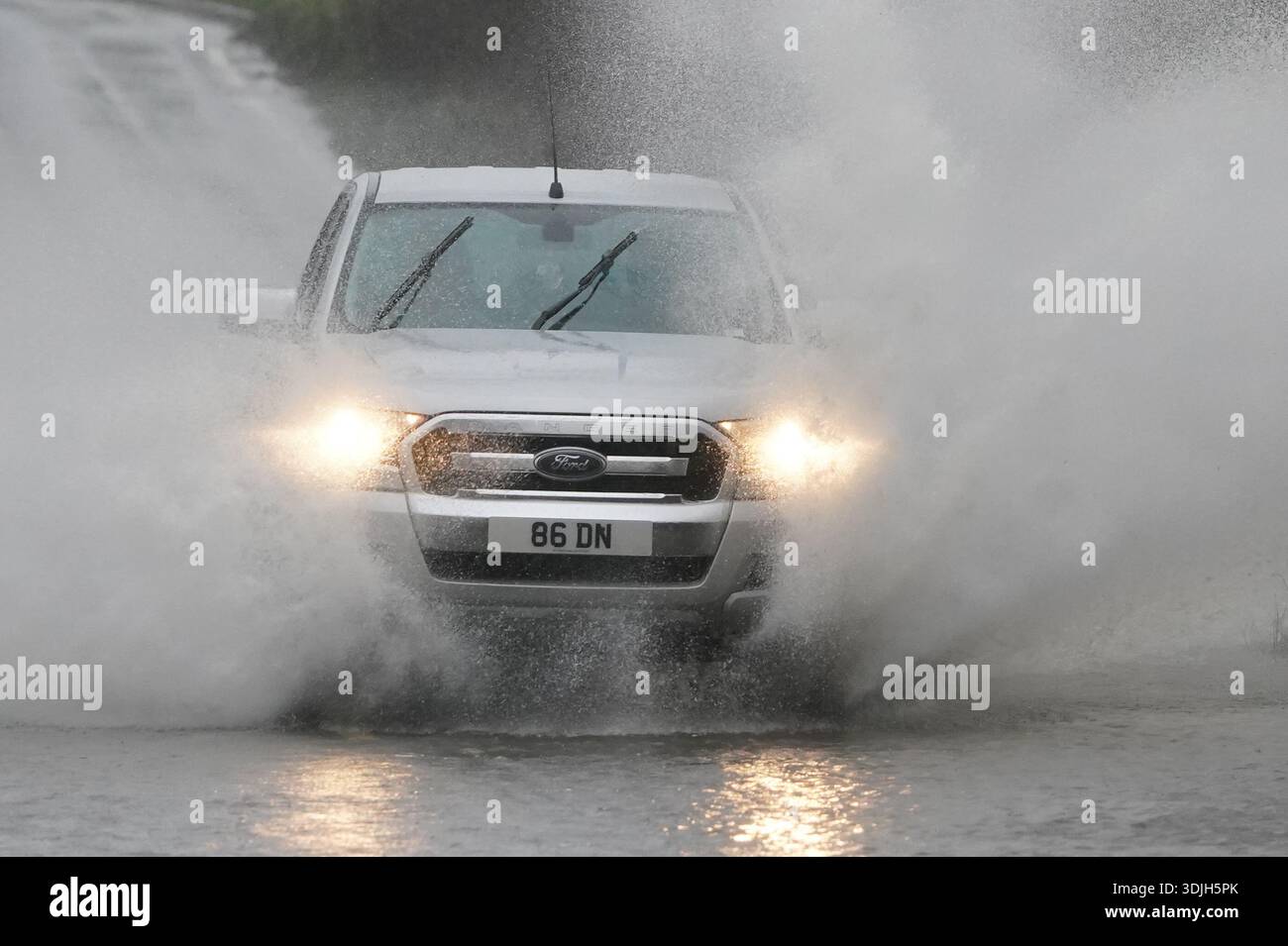 A vehicle driving through the pooled rainwater on the A20 in Ashford ...