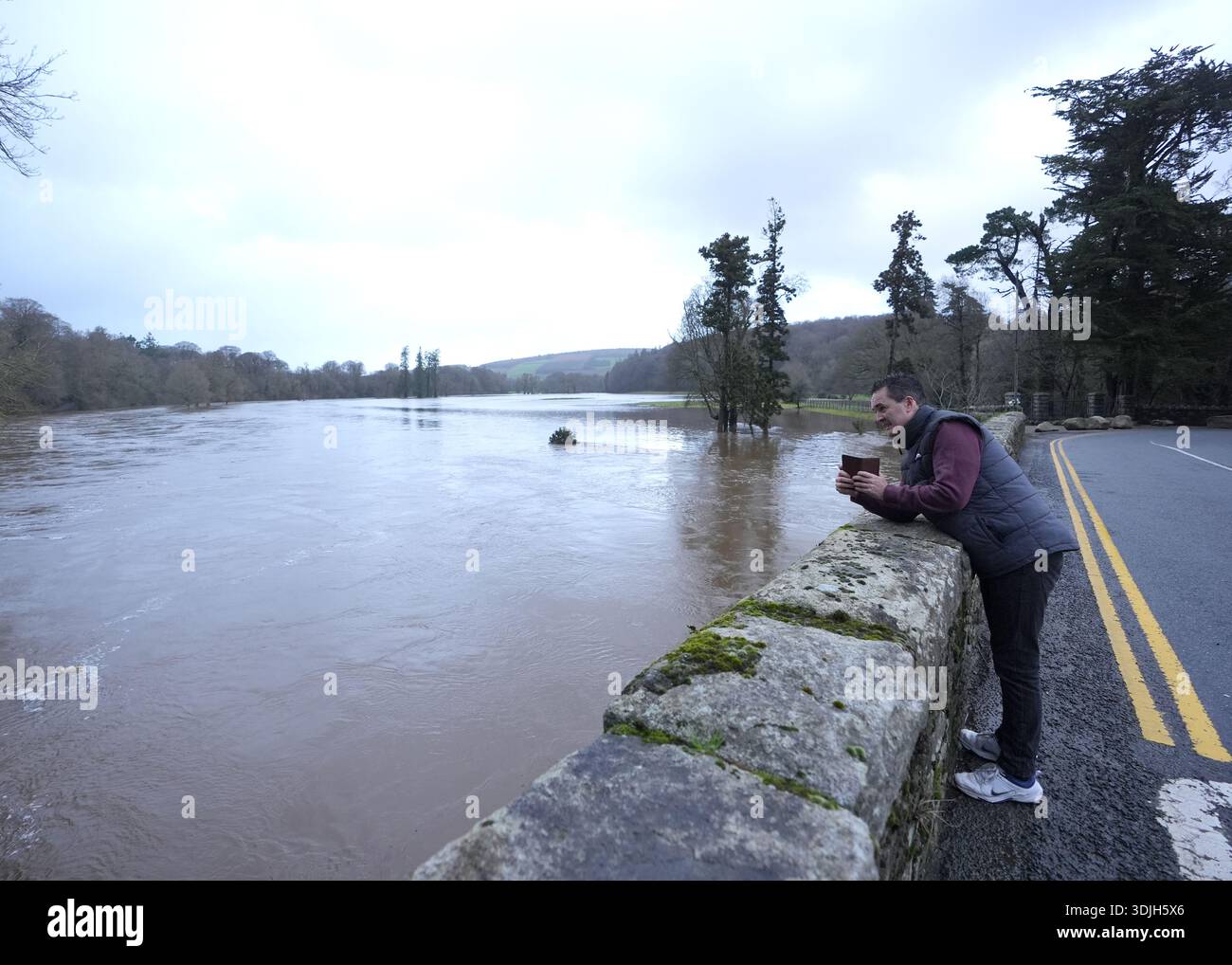 A man photographs the overflowing River Slaney in Bunclody, Co. Wexford ...