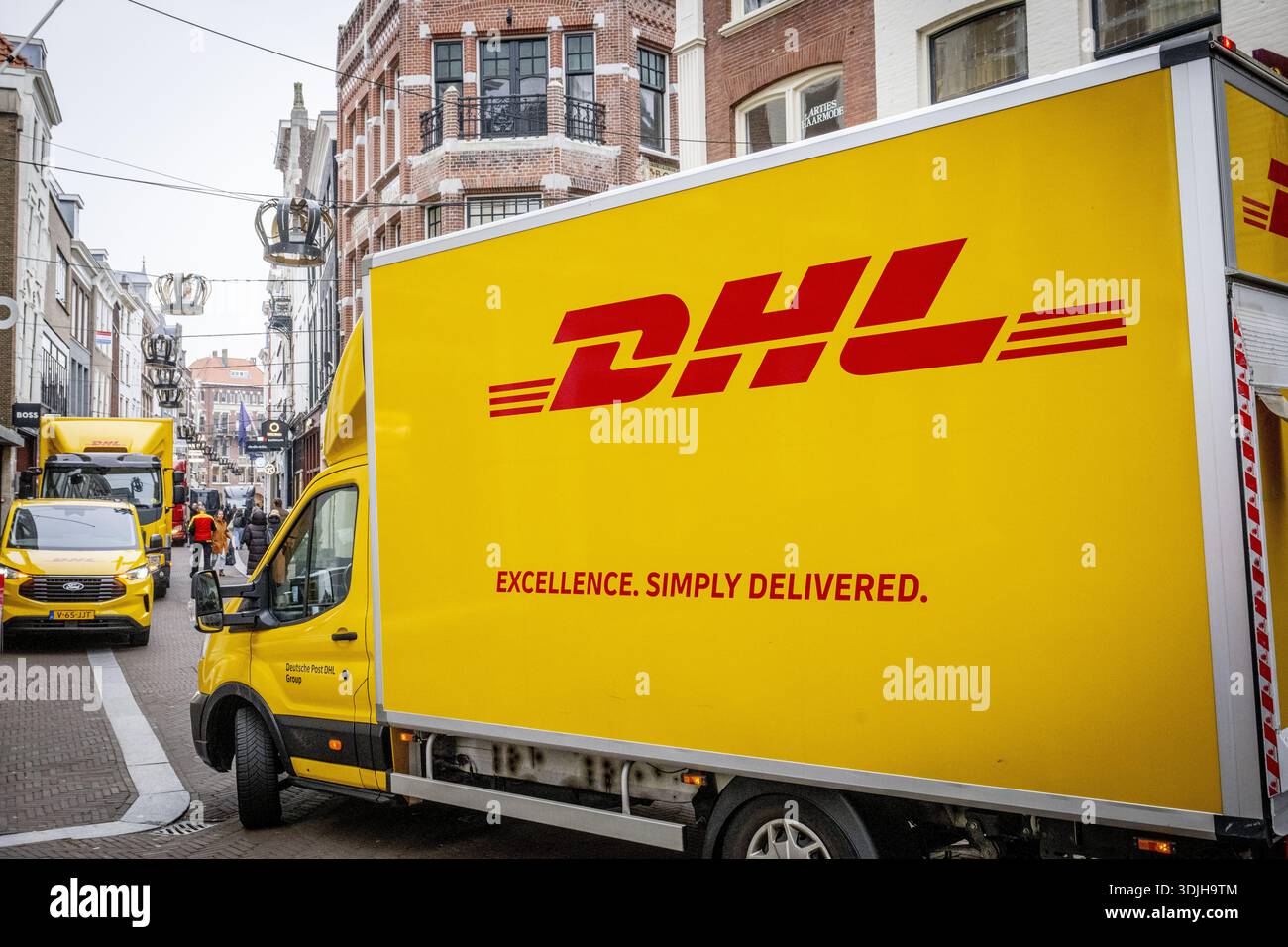 THE HAGUE - Delivering a DHL package with a truck in the city center ...