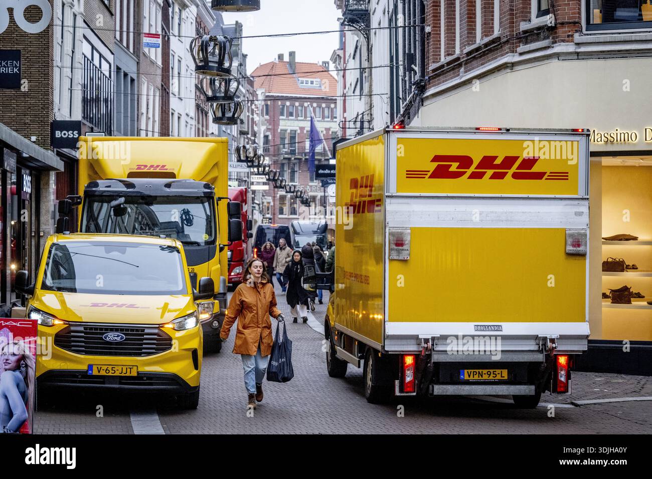 THE HAGUE - Delivering a DHL package with a truck in the city center ...