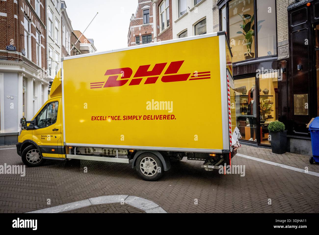 THE HAGUE - Delivering a DHL package with a truck in the city center ...