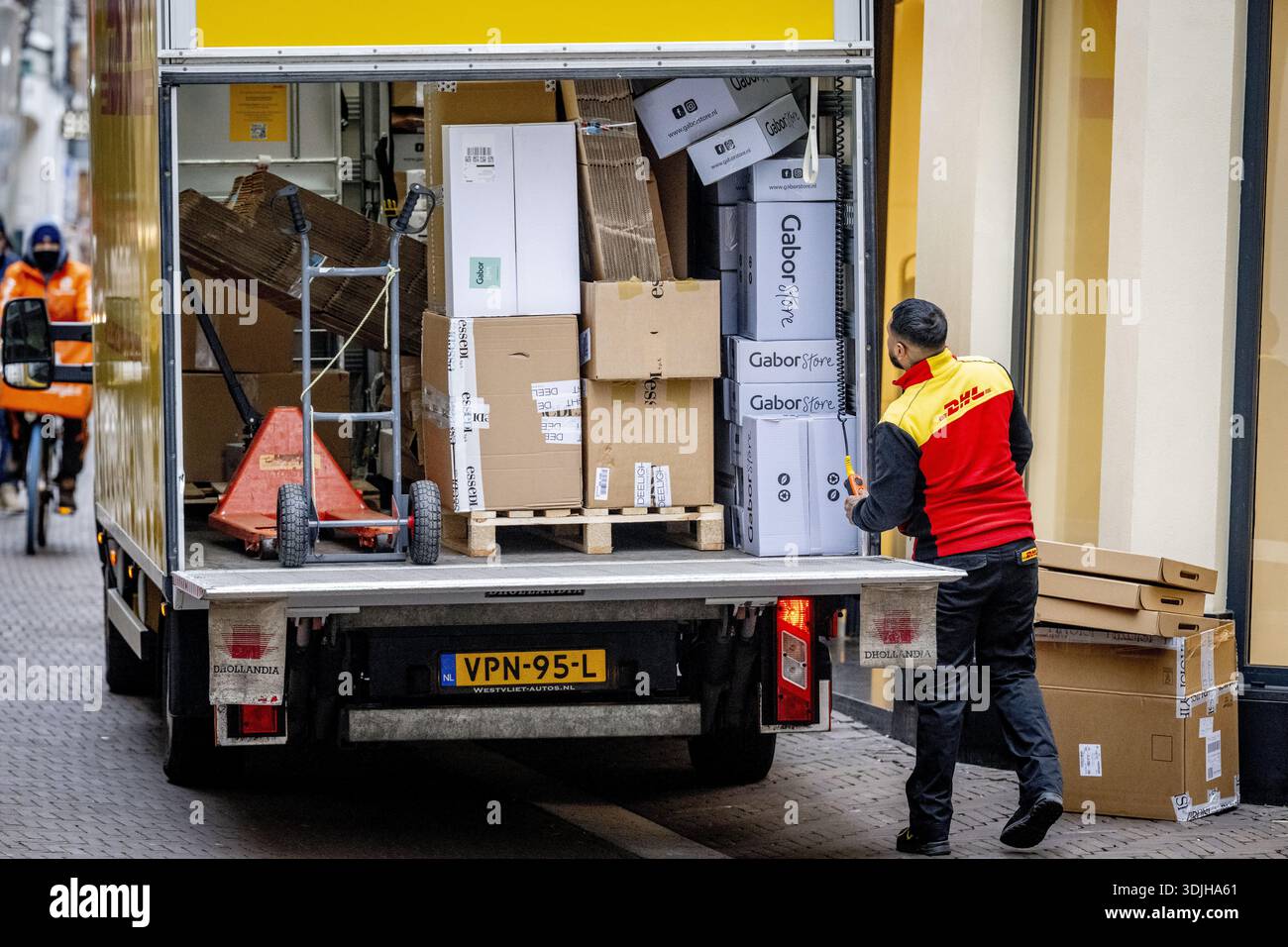 THE HAGUE - Delivering a DHL package with a truck in the city center ...