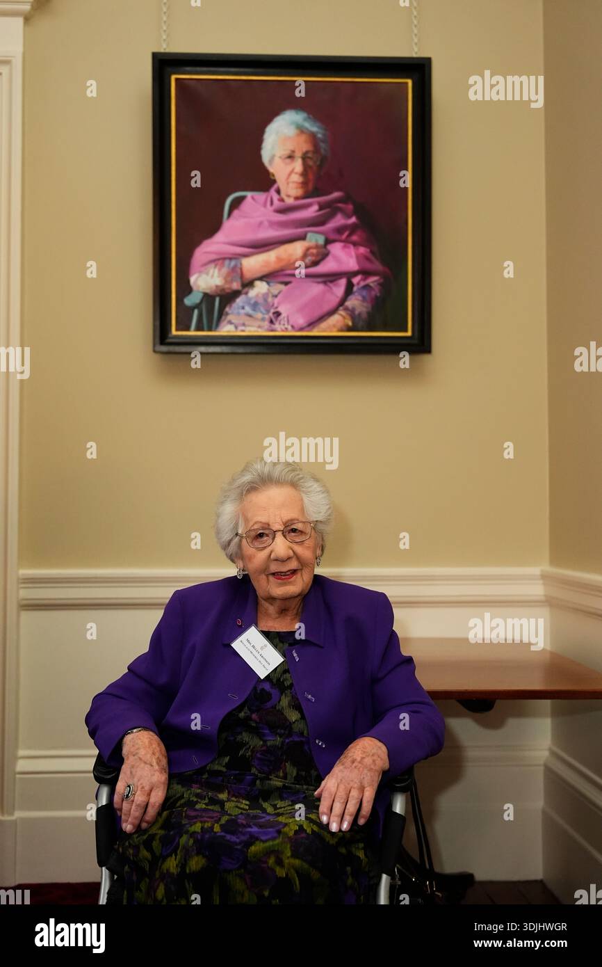 Holocaust survivor Helen Aronsen sits beneath a portrait of herself ...