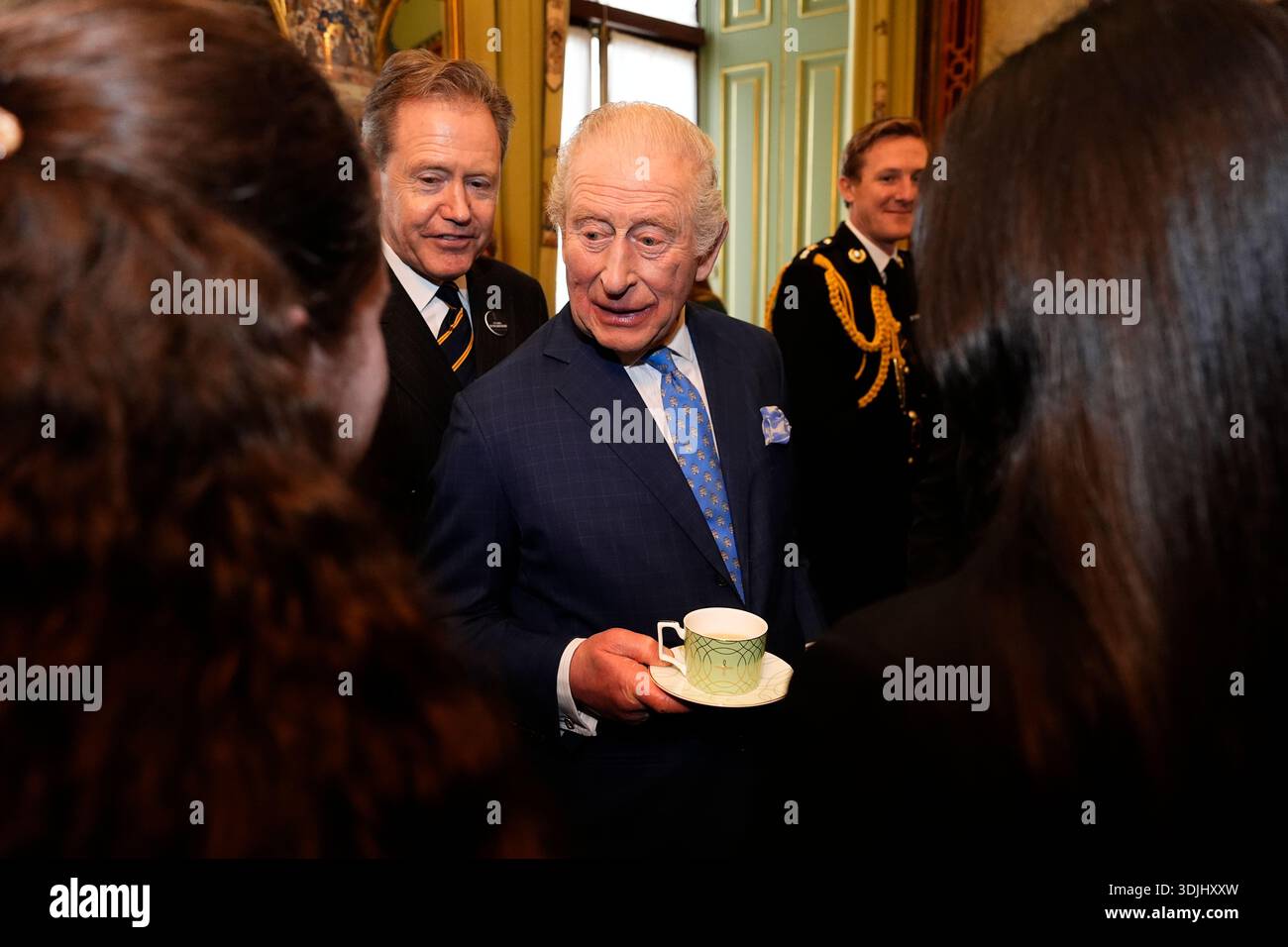 King Charles III speaks with guests during a reception at Buckingham ...