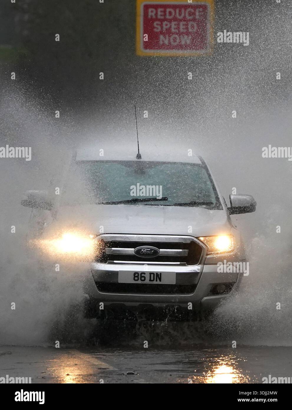 A car passes through a flooded area of the A20 near Ashford in Kent ...