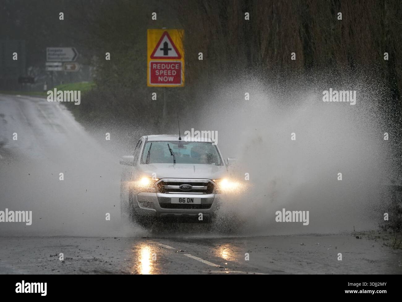 A car passes through a flooded area of the A20 near Ashford in Kent ...