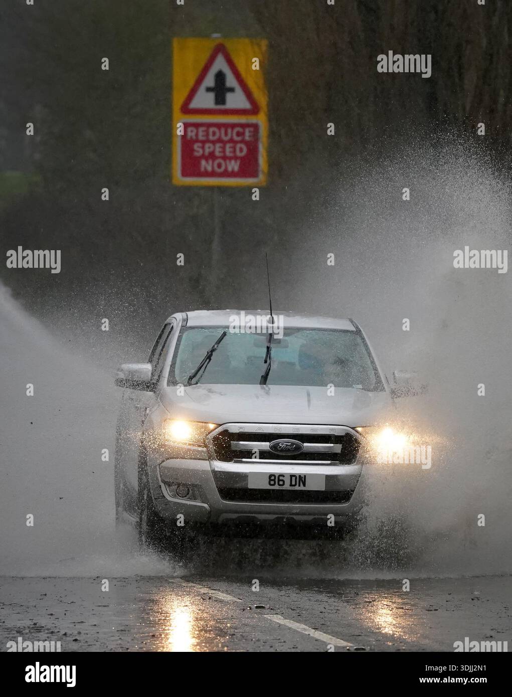 A car passes through a flooded area of the A20 near Ashford in Kent ...