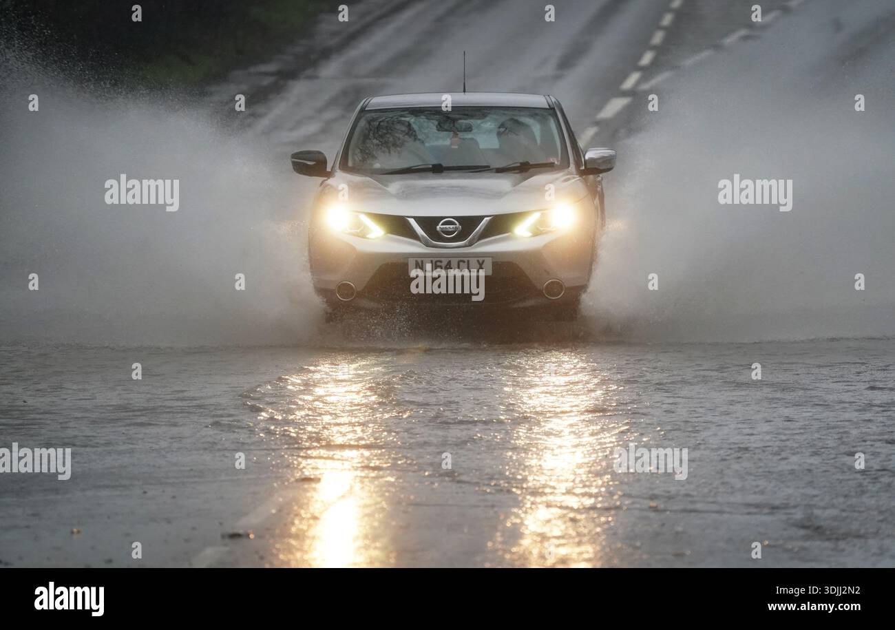 A car passes through a flooded area of the A20 near Ashford in Kent ...