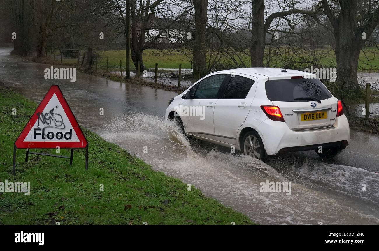 A car passes through a flooded road in Ashford, Kent. Storm Chandra ...