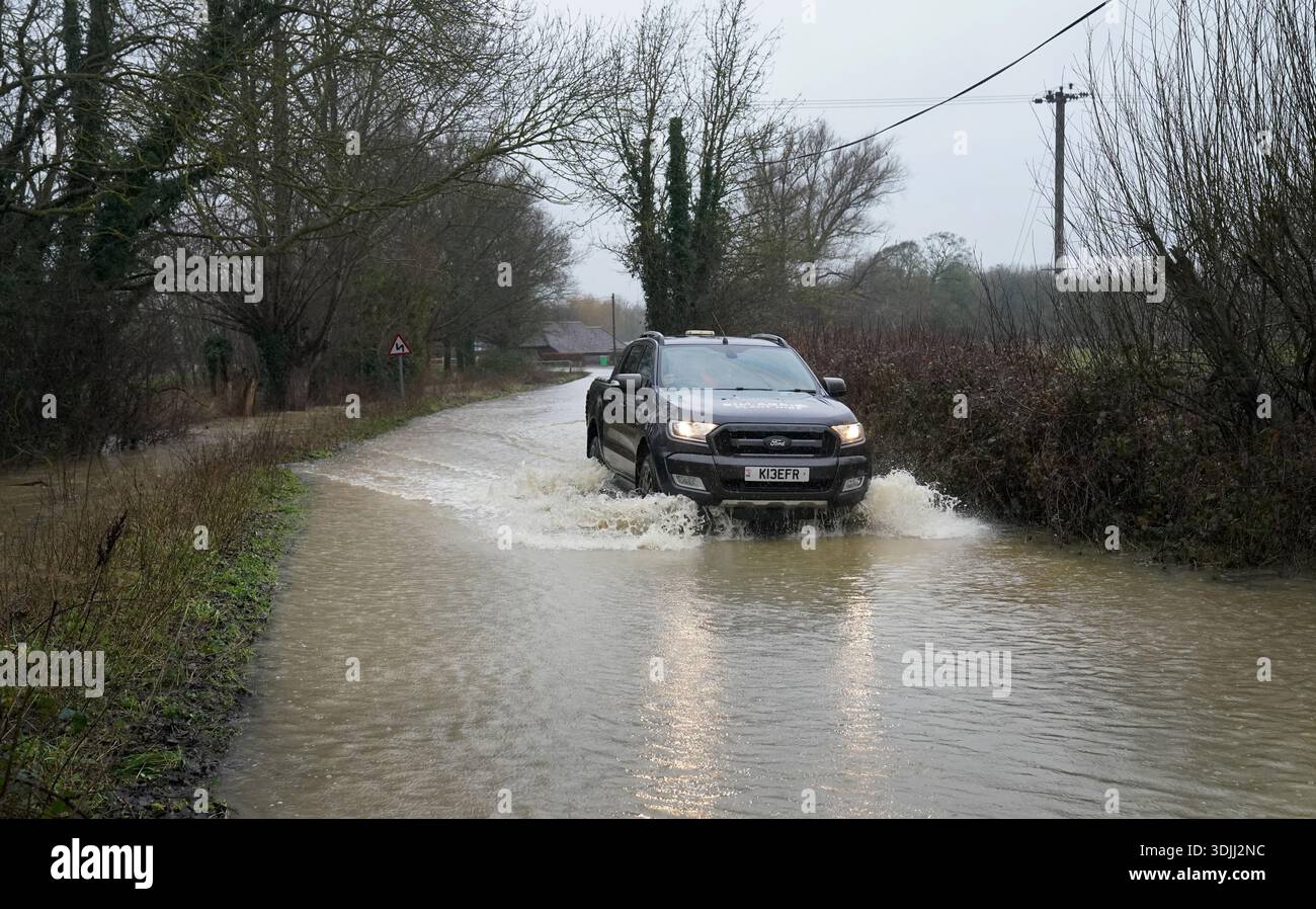 A car passes through a flooded road in Ashford, Kent. Storm Chandra ...