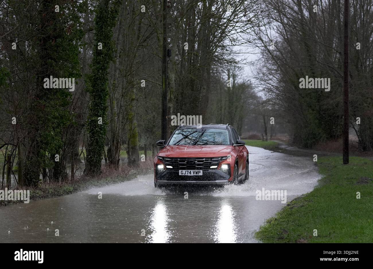 A car passes through a flooded road in Ashford, Kent. Storm Chandra ...