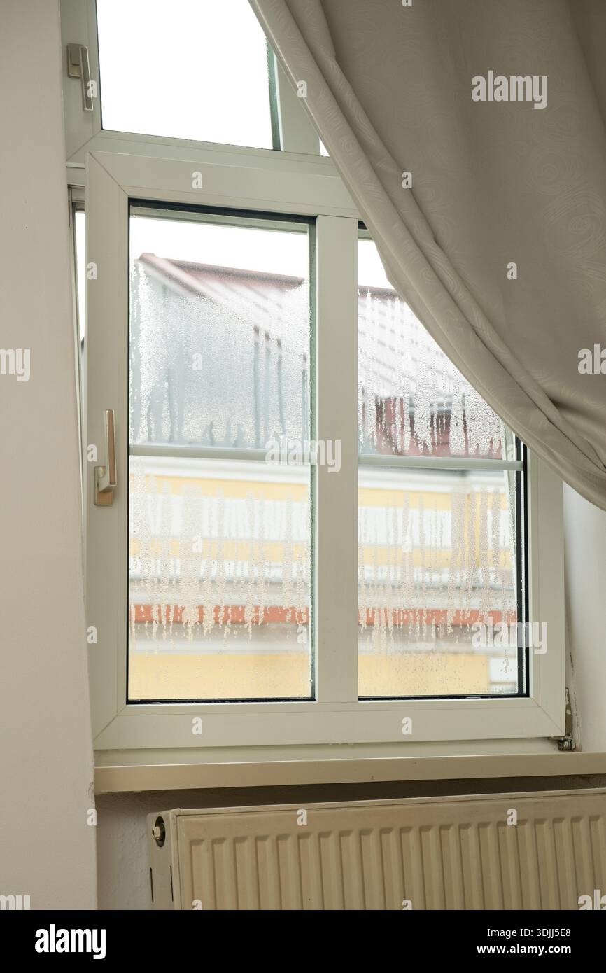 Plastic window with heavy condensation and water droplets. Indoor ...