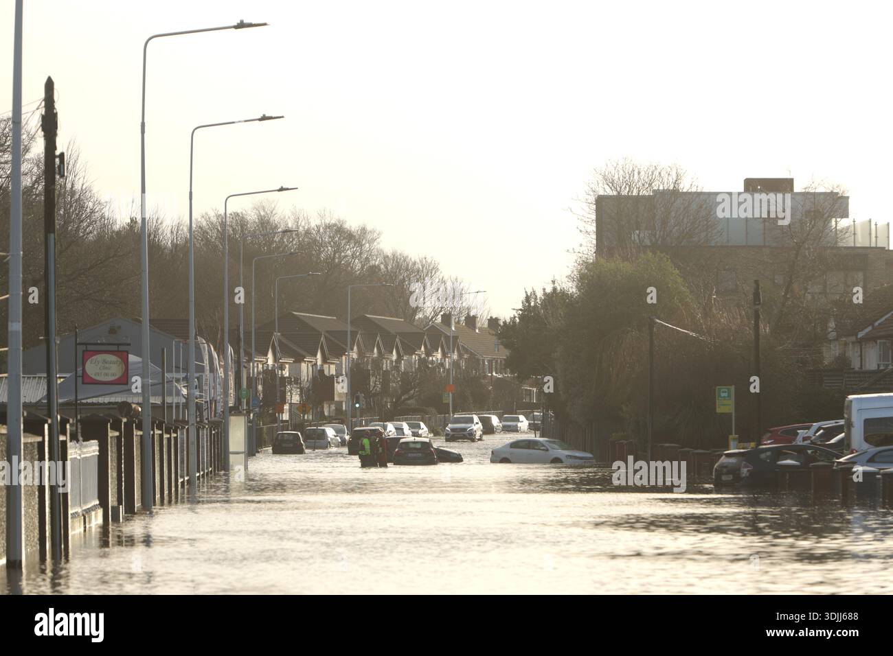 Dublin, Ireland - 27th January 2026: Sun rises over a flooded road in ...