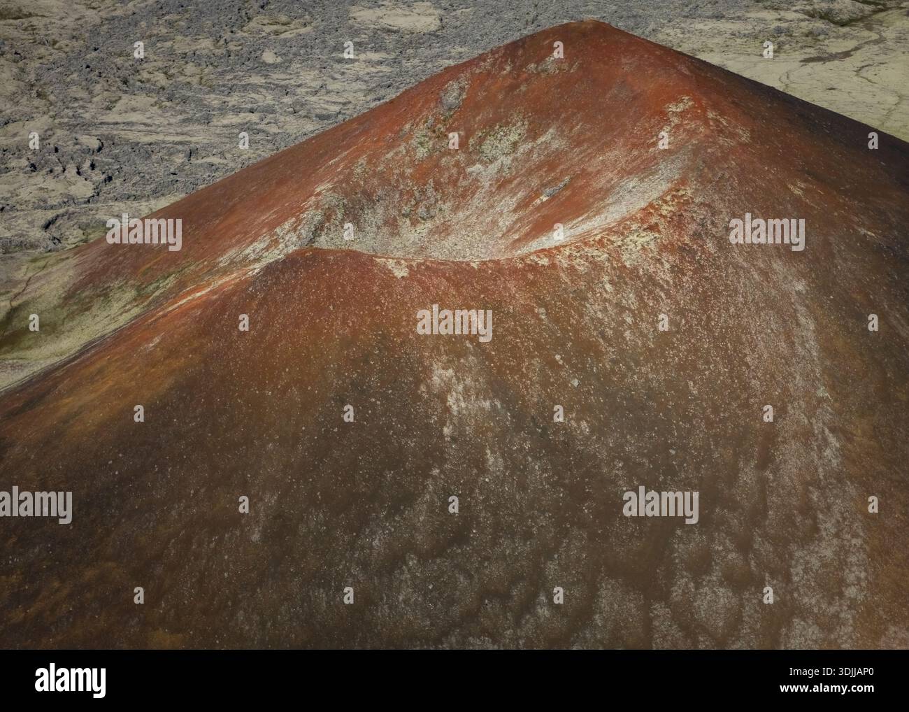 Aerial view of the stark, rust-colored volcanic cone rises dramatically ...