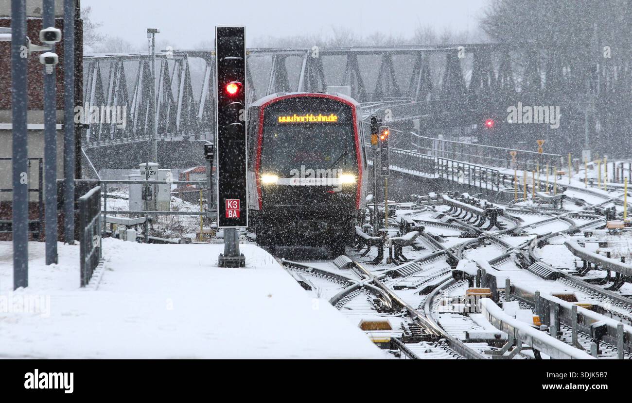 Eine U-Bahn der Hamburger Hochbahn AG steht im Schneetreiben vor dem ...