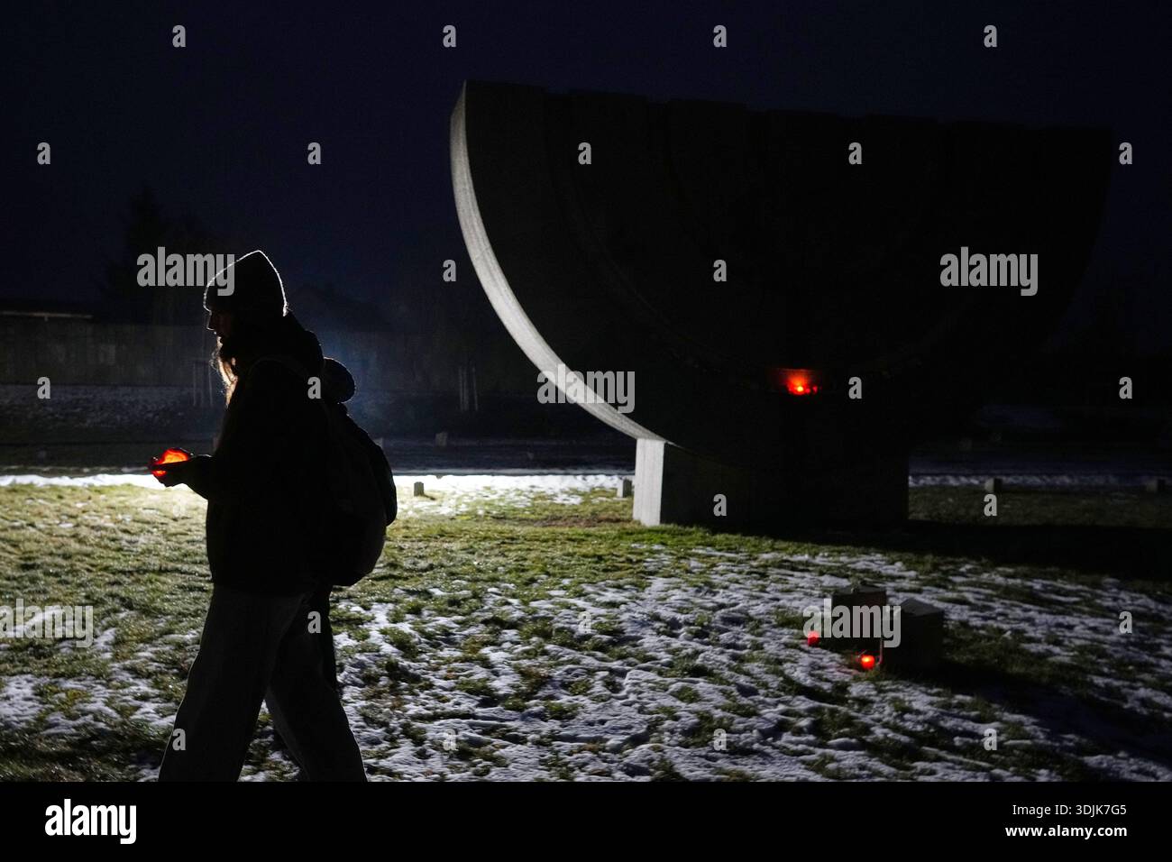 A woman walks with a candle during the International Holocaust ...