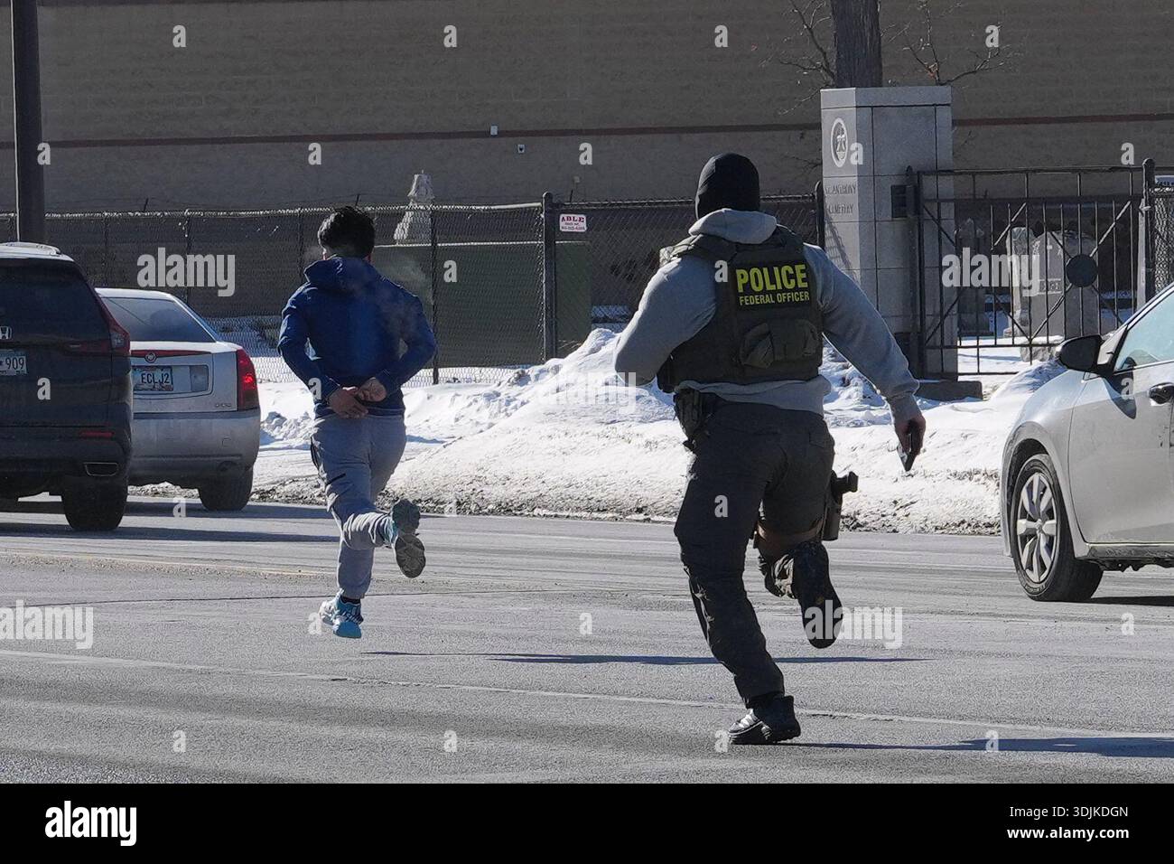 A man in handcuffs runs to avoid being detailed by federal immigration ...