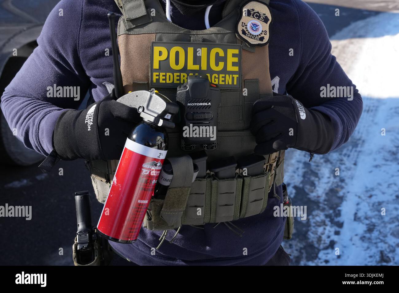 A federal agent holds a chemical canister as they question a person on ...