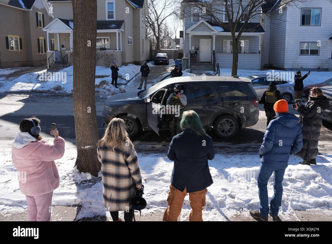 People watch as federal agents detain a person, Tuesday, Jan. 27, 2026 ...