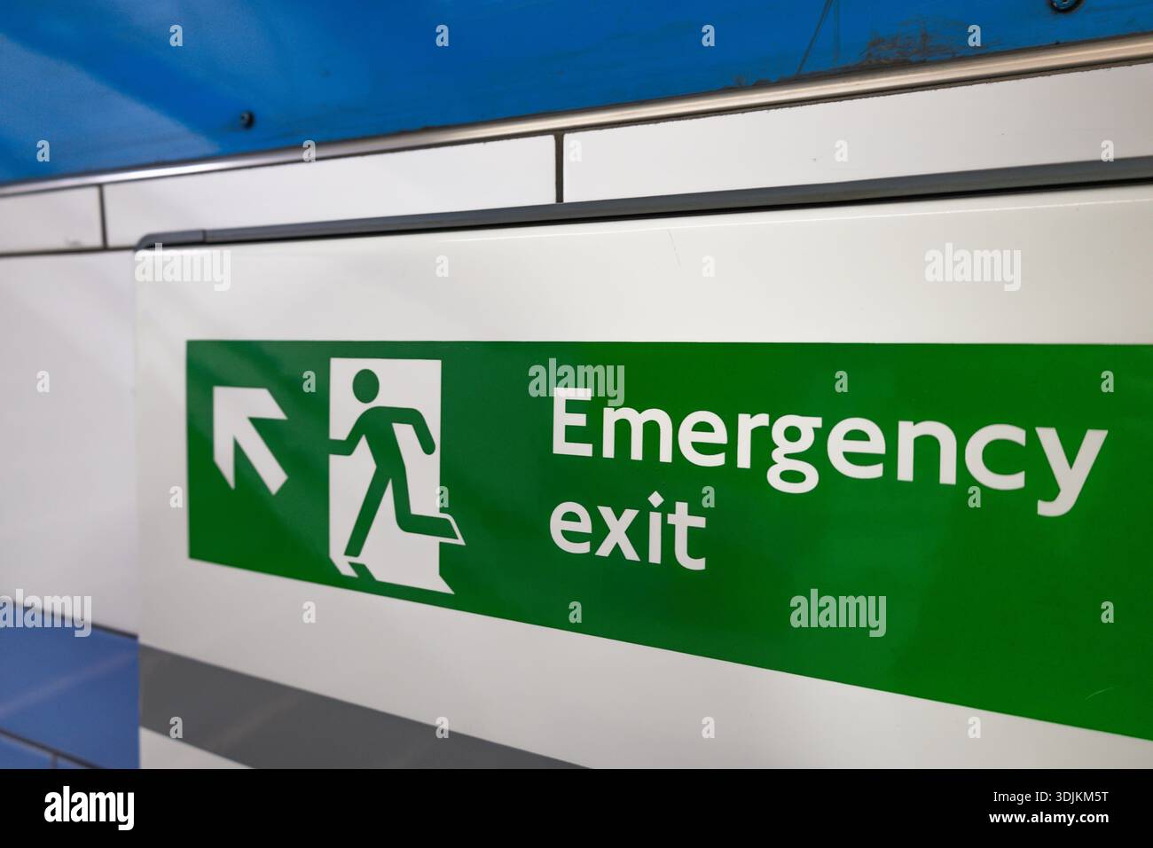 Green Emergency Exit Sign in Metro Station Stock Photo - Alamy
