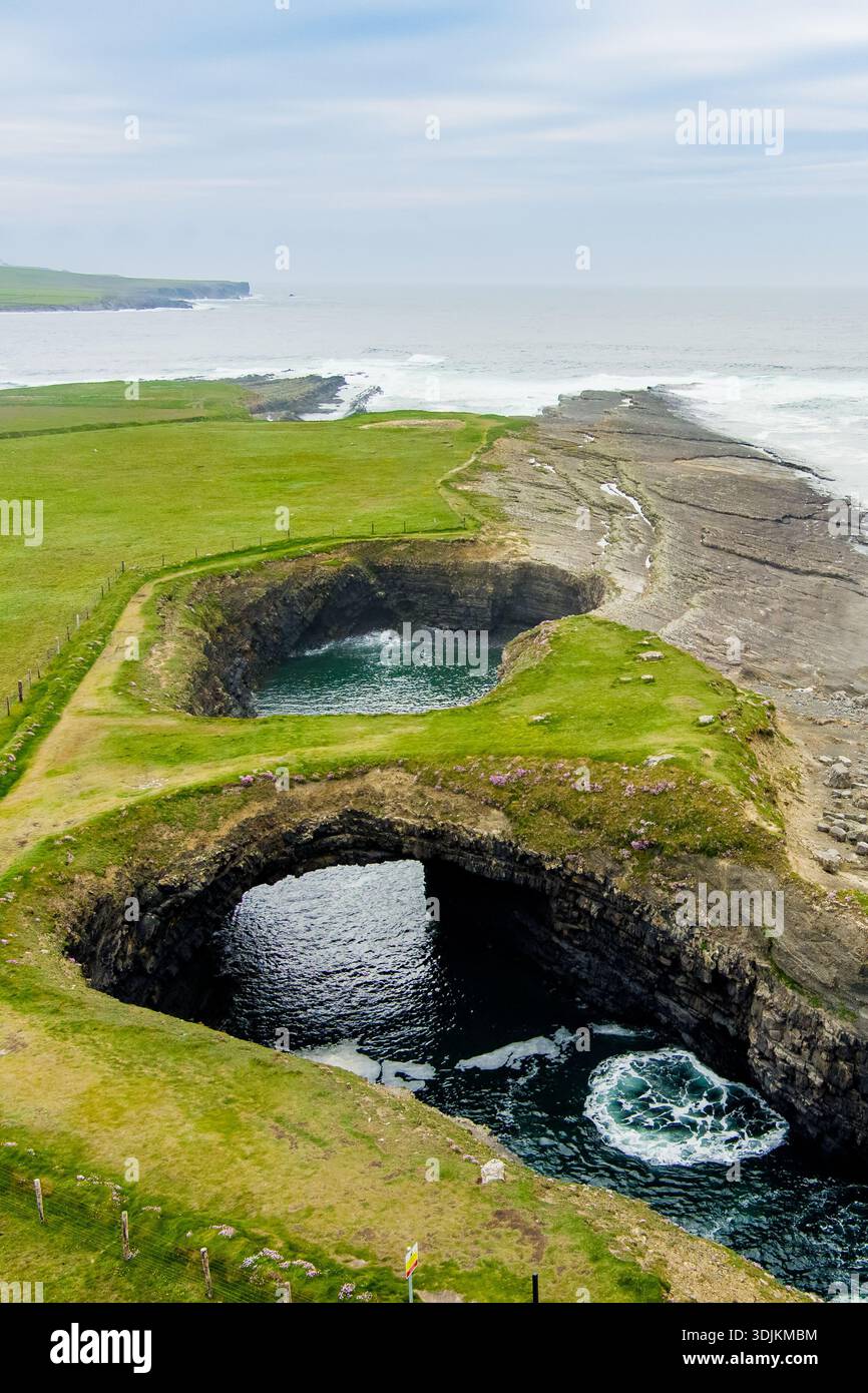 Aerial view of Bridges of Ross, three natural rock arches, carved into ...