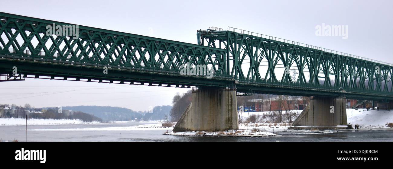 Large green steel truss bridge crossing a river in winter. Industrial ...