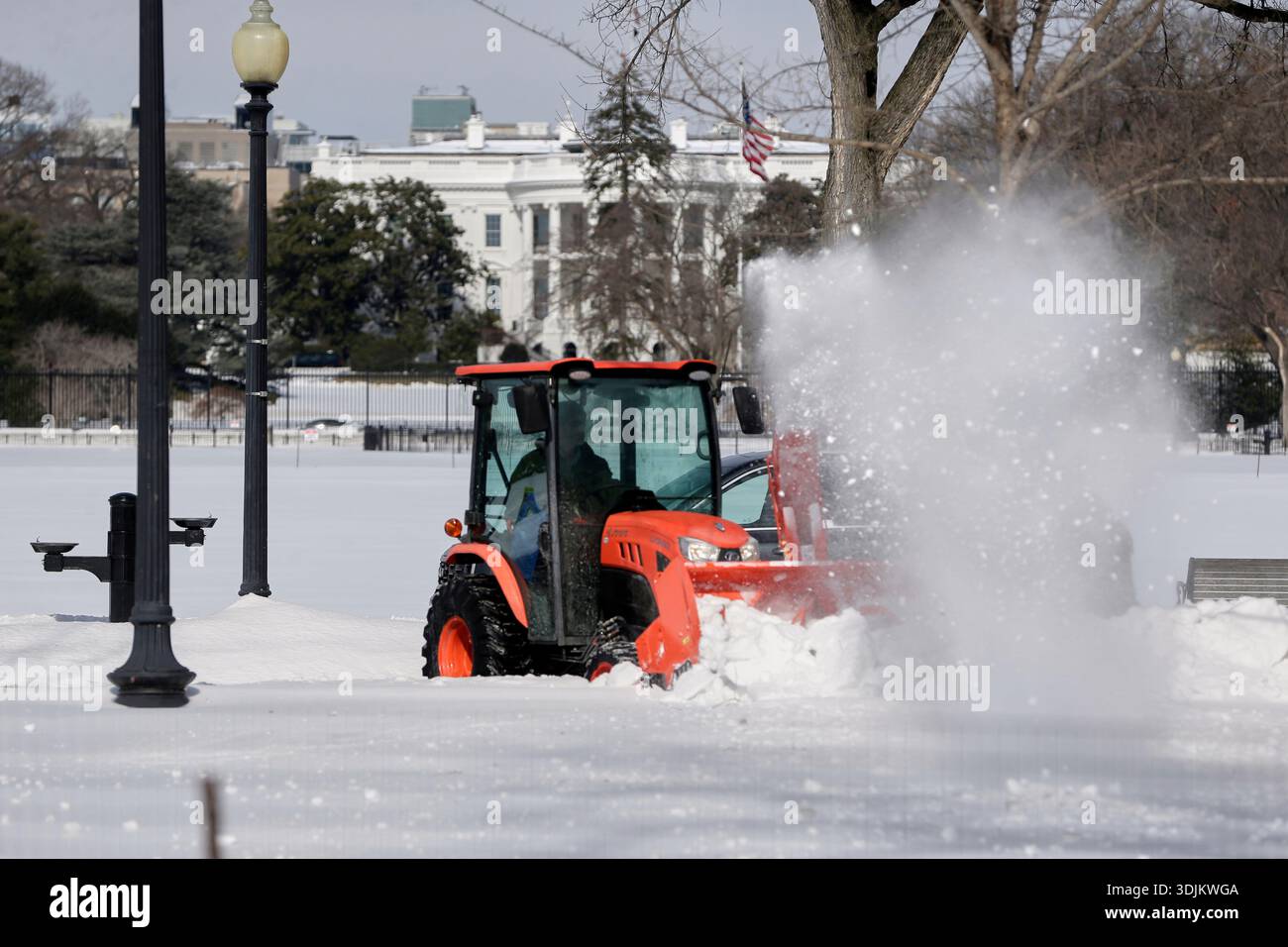 A worker clears snow on the Ellipse near the White House, after a ...