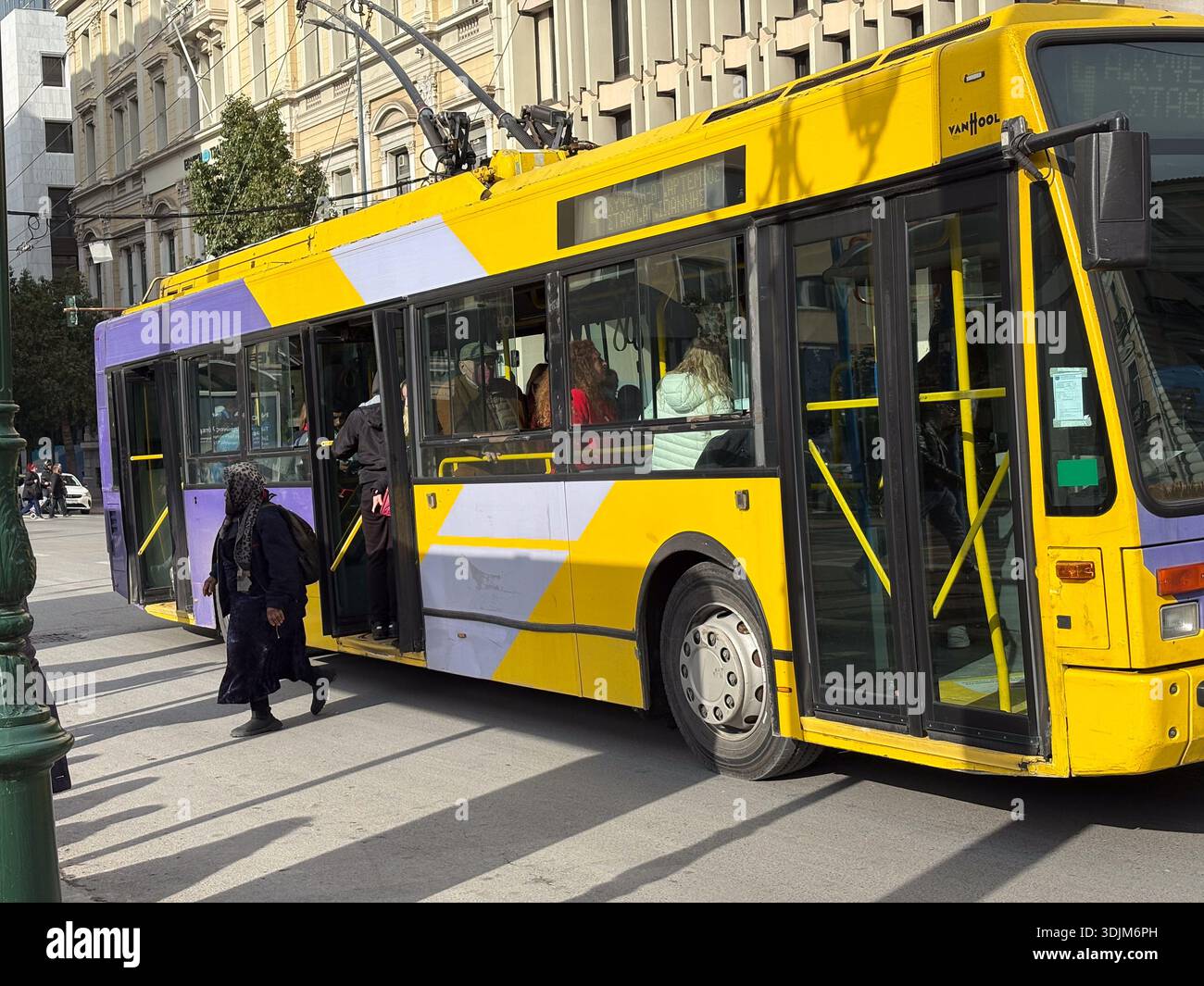 Yellow and purple Van Hool trolleybus, part of the Athens public ...