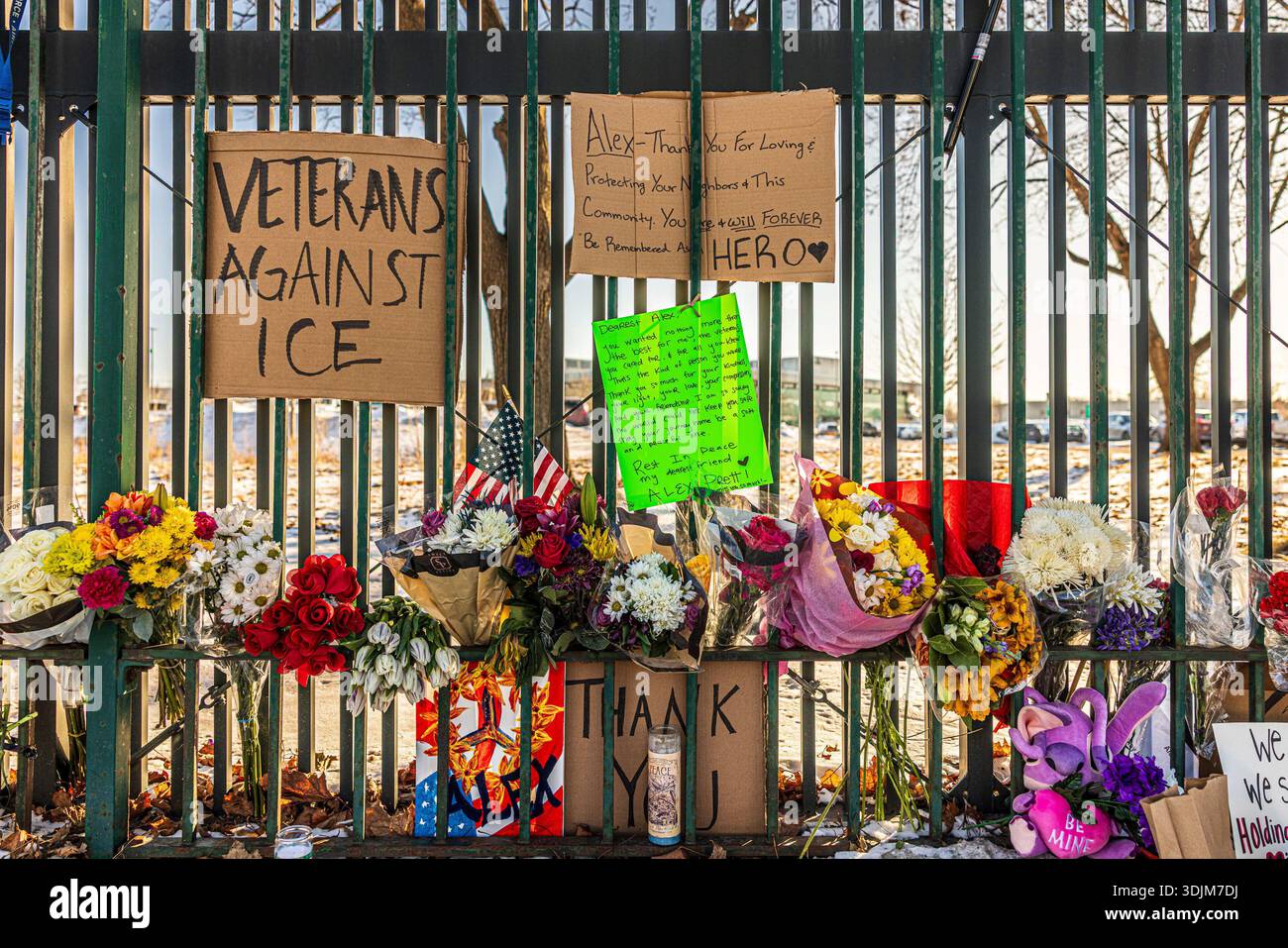 Flowers, flags and handwritten signs, including messages reading ...